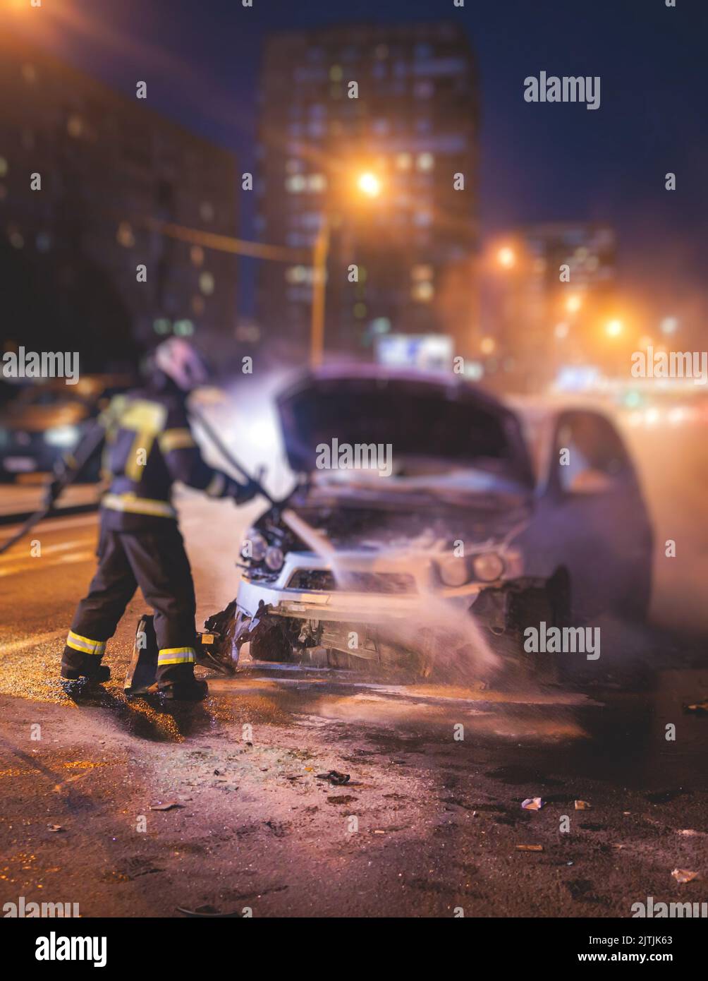 Group of fire men extinguishing and put out burning car crash after ...