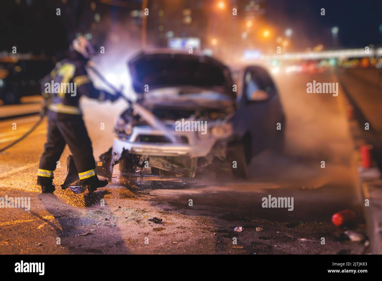 Group of fire men extinguishing and put out burning car crash after ...
