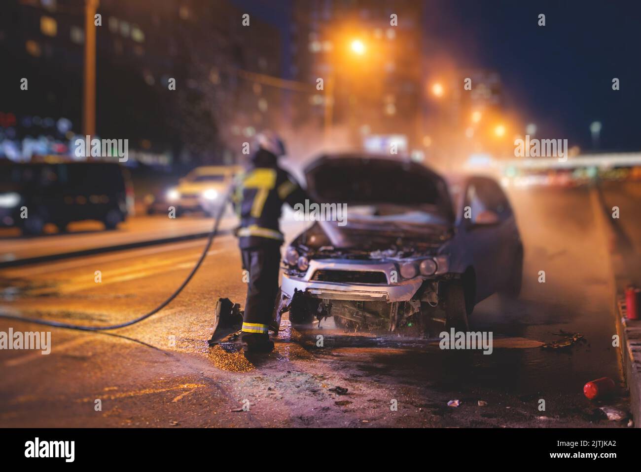 Group of fire men extinguishing and put out burning car crash after ...