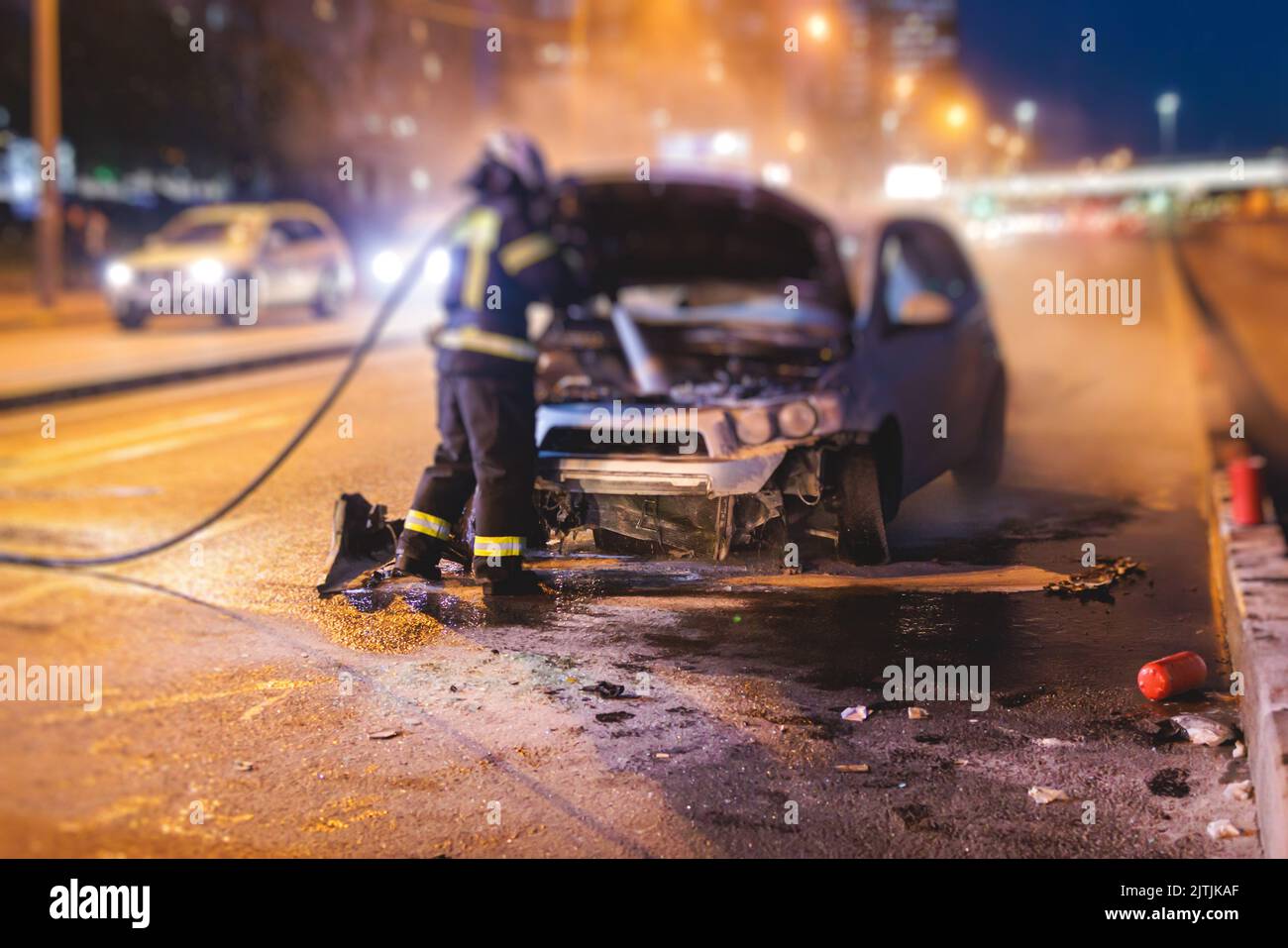 Group of fire men extinguishing and put out burning car crash after ...