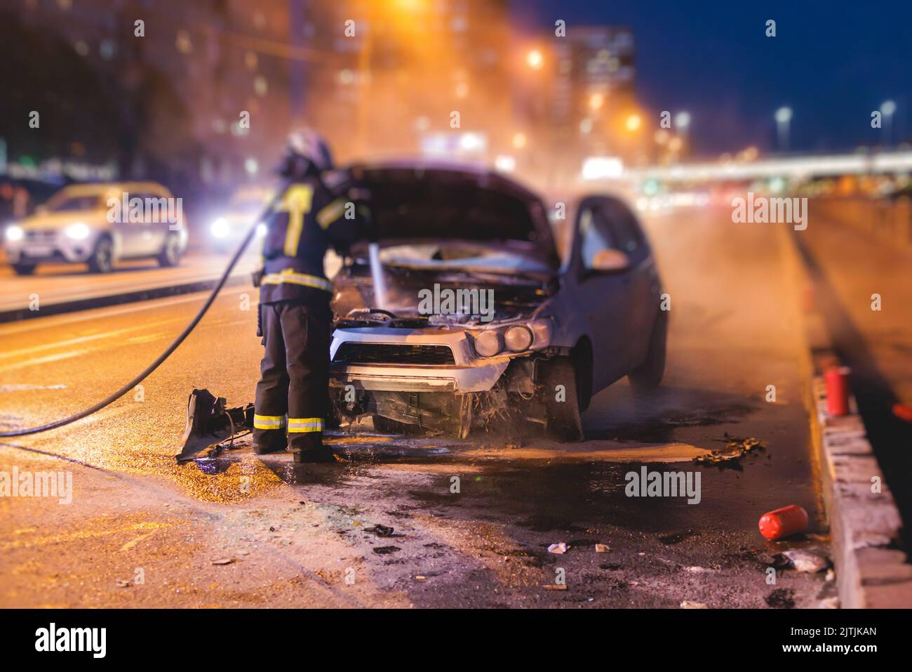Group of fire men extinguishing and put out burning car crash after ...