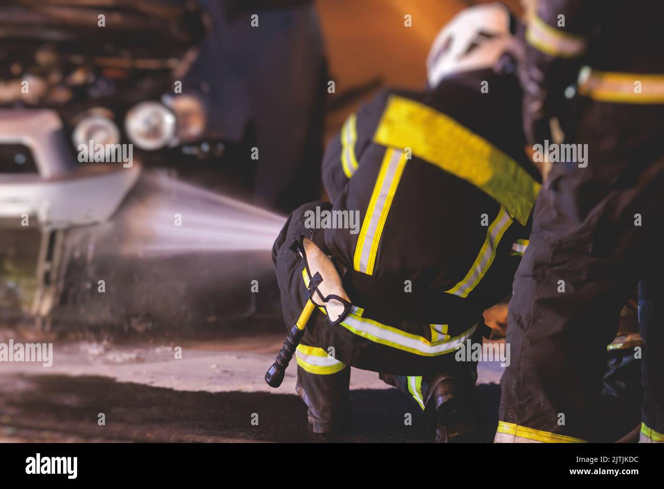 Group of fire men extinguishing and put out burning car crash after ...