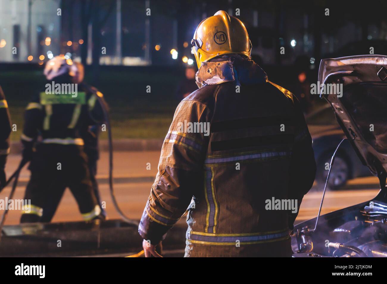 Group of fire men in uniform during fire fighting operation in the ...