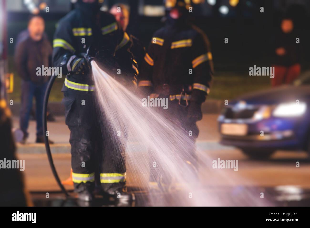 Group of fire men in uniform during fire fighting operation in the ...