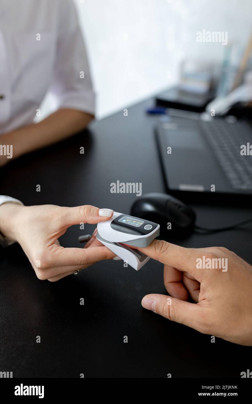 Woman doctor measures by pulse oximeter blood oxygen saturation for ...