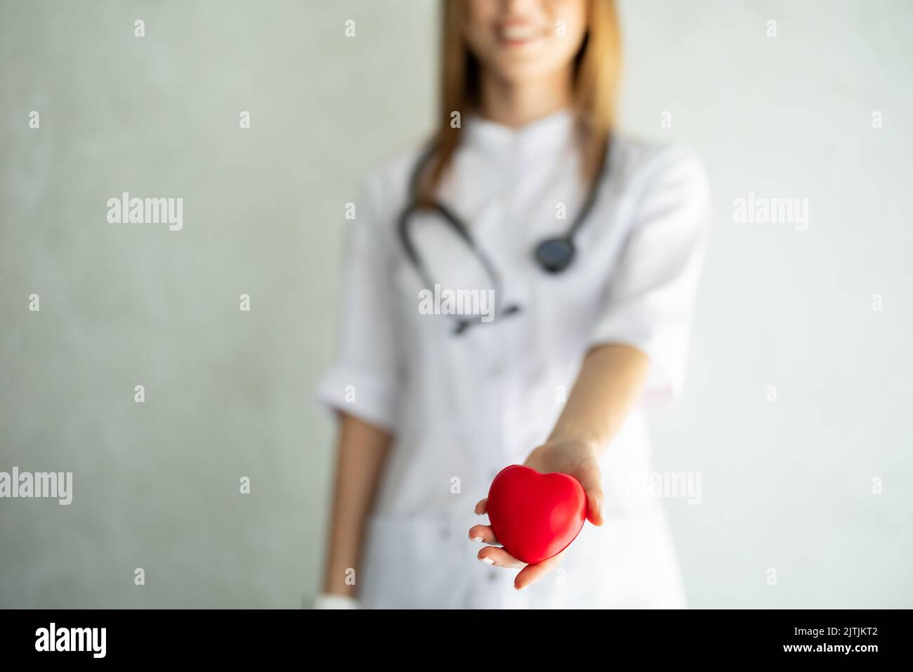 Woman Cardiologist Doctor Holds And Shows Heart Red Model In Clinic