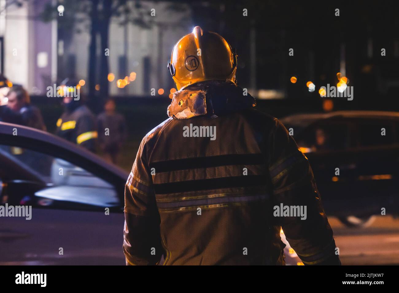 Group of fire men in uniform during fire fighting operation in the ...