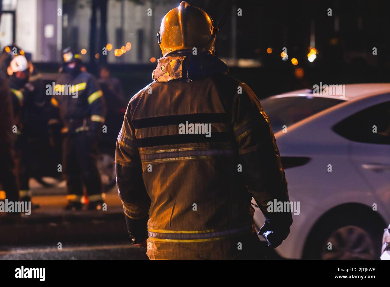 Group of fire men in uniform during fire fighting operation in the ...