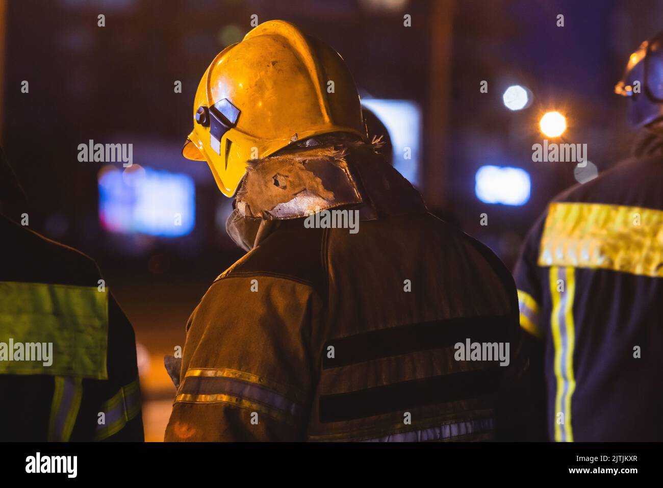 Group of fire men in uniform during fire fighting operation in the ...