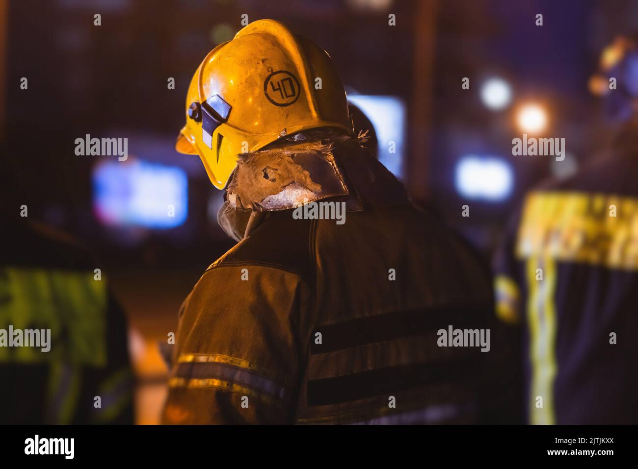Group of fire men in uniform during fire fighting operation in the ...