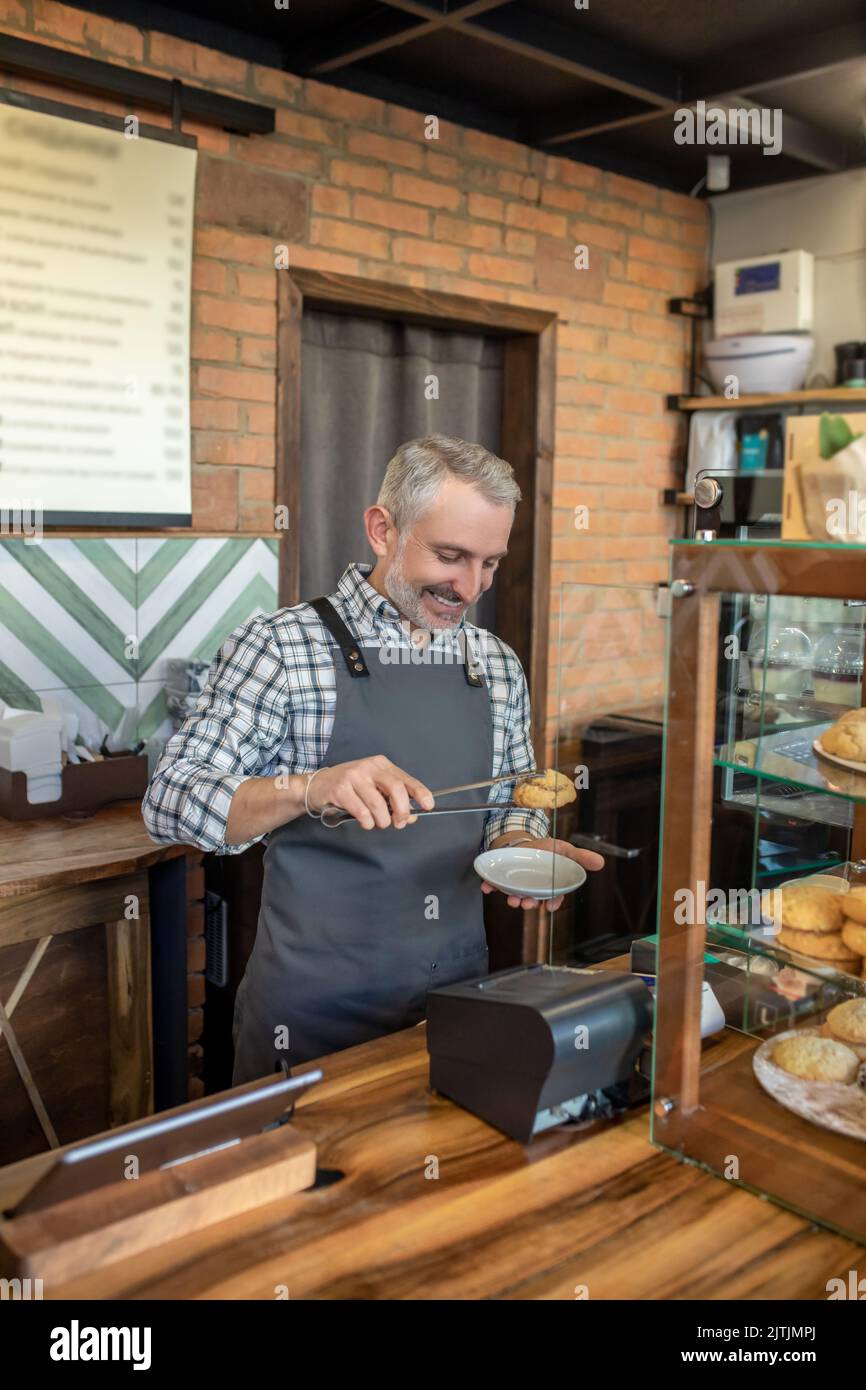Cheerful cafe worker employee serving a customer Stock Photo - Alamy