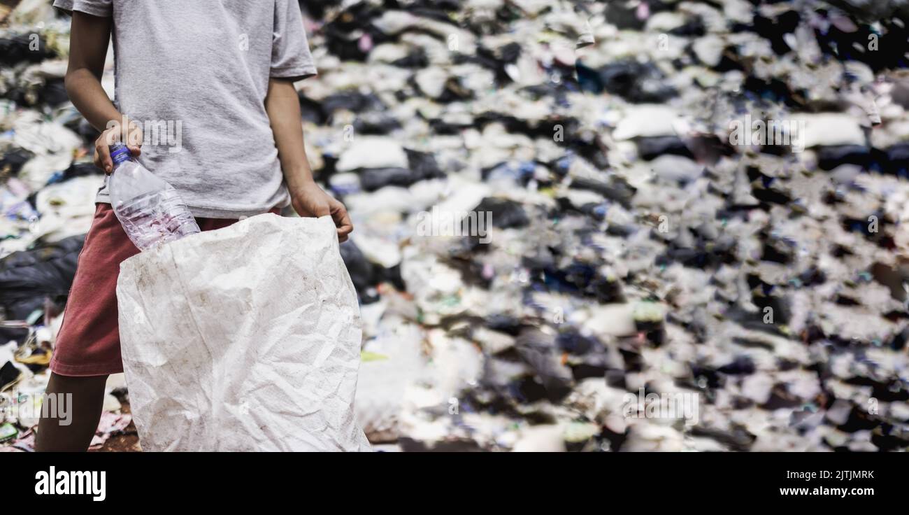 A young poor Indian boy collection waste plastic bottles in his sack to ...
