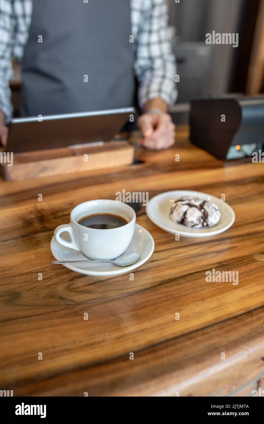 Cafe employee dressed in the apron standing at the counter Stock Photo ...