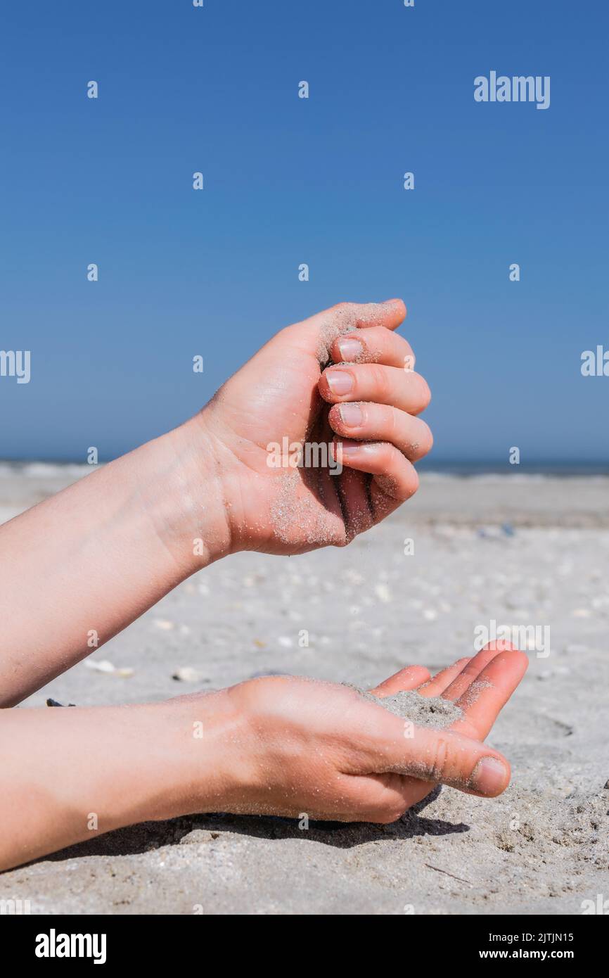 Women hands playing with the sand on the beach Stock Photo - Alamy