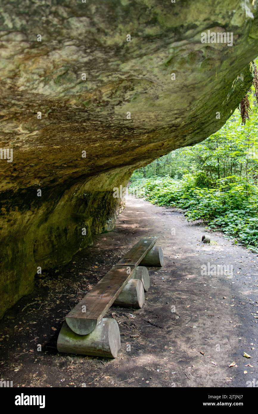 Log benches on the rest area under the rock overhang Stock Photo - Alamy