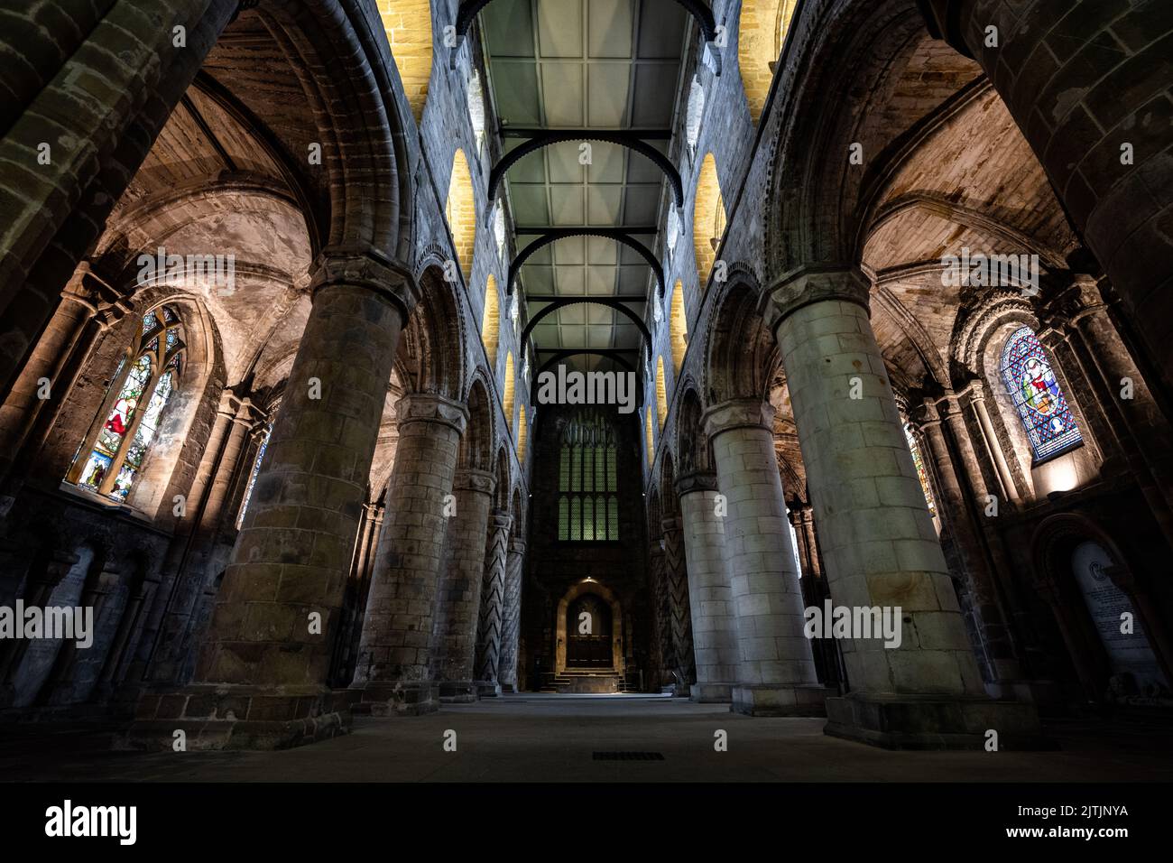 The interior of an ancient stone cathedral with pillars, arches, and ...