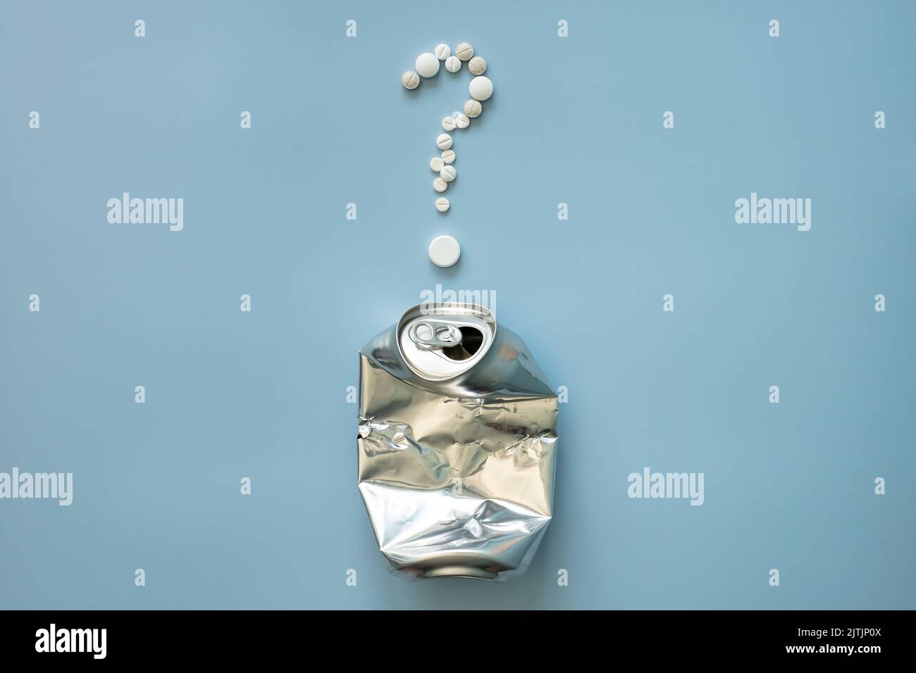 Pills are laid out in the form of a question mark over a crumpled ...