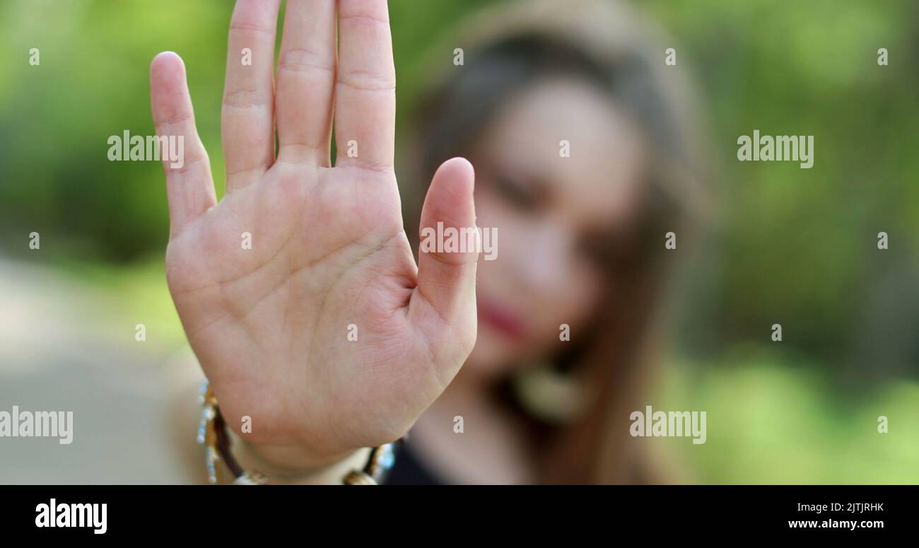 Young attractive woman blocking with hand. Pretty girl signalling to ...
