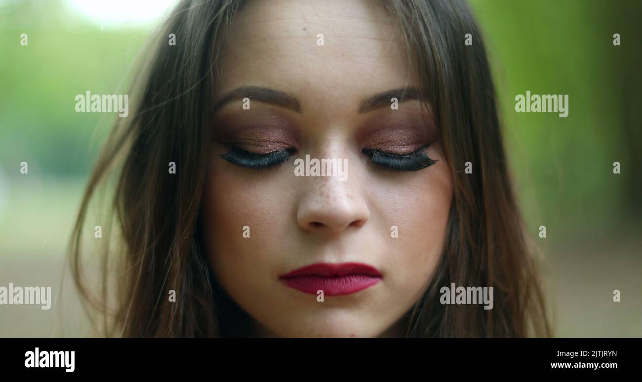 Young woman face opening eyes looking to camera. Pretty serious girl in ...