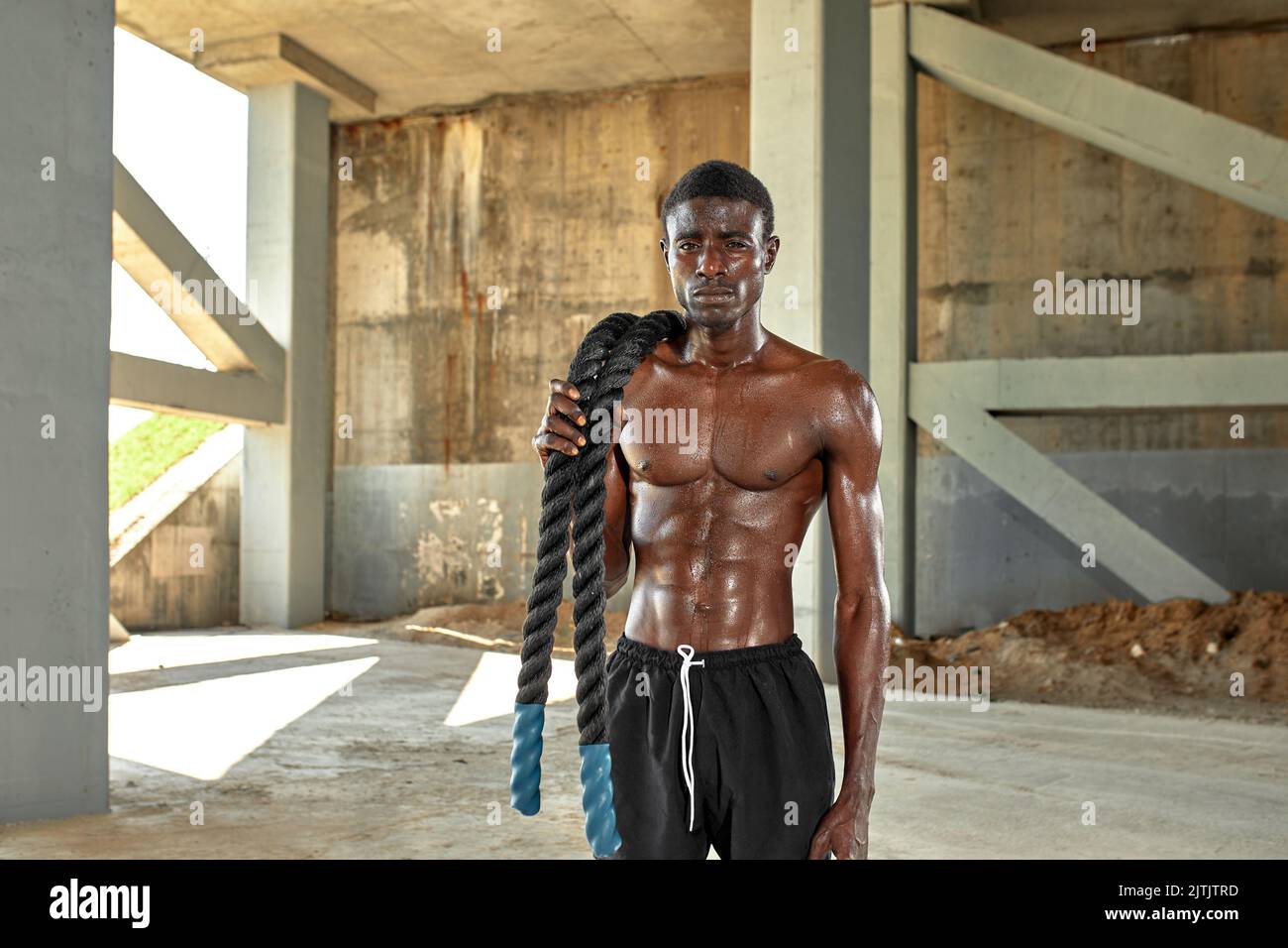 Rope workout. Sport man doing battle ropes exercise outdoor. Black male ...