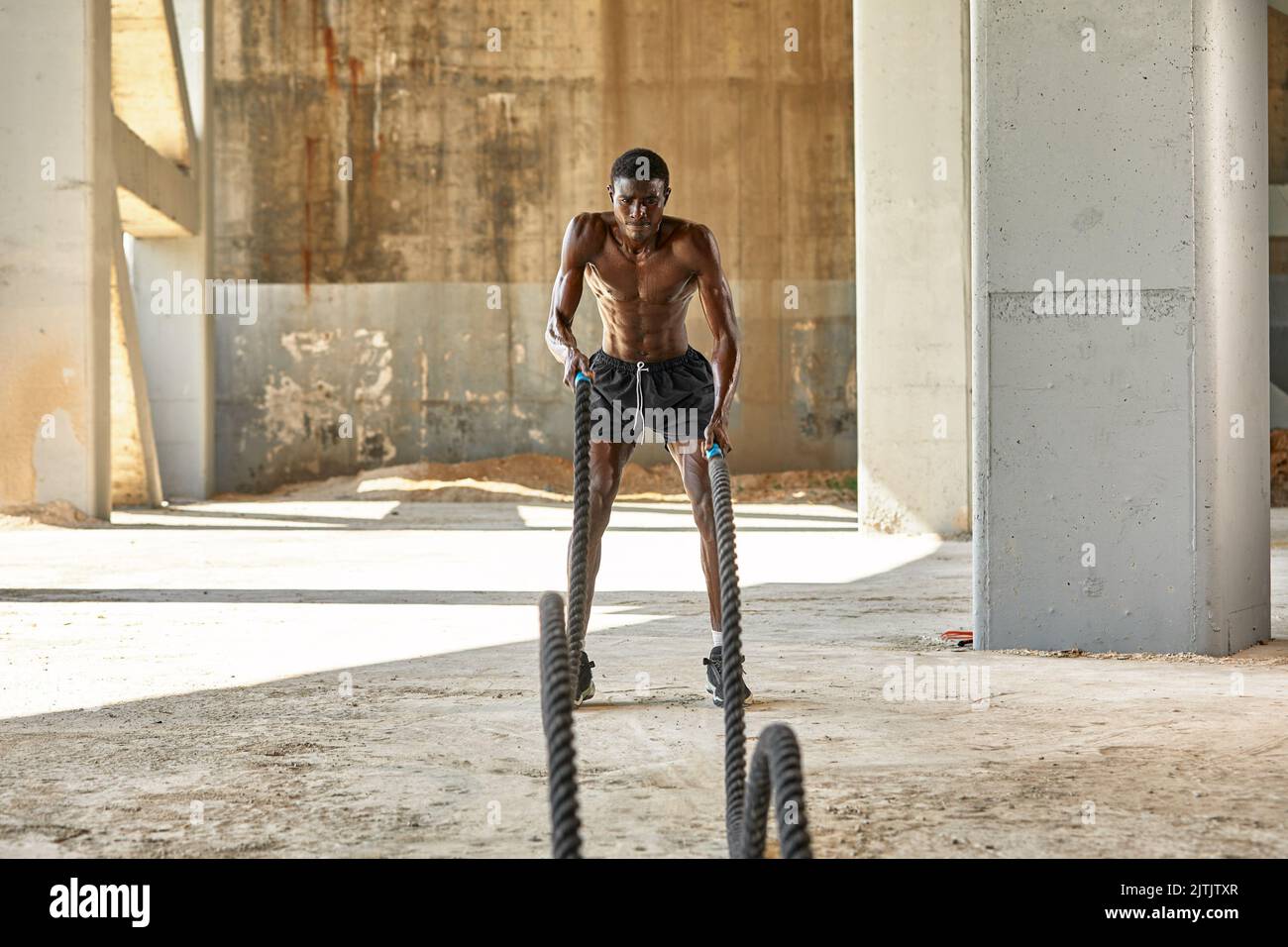 Sportsman doing heavy rope training hi-res stock photography and images ...