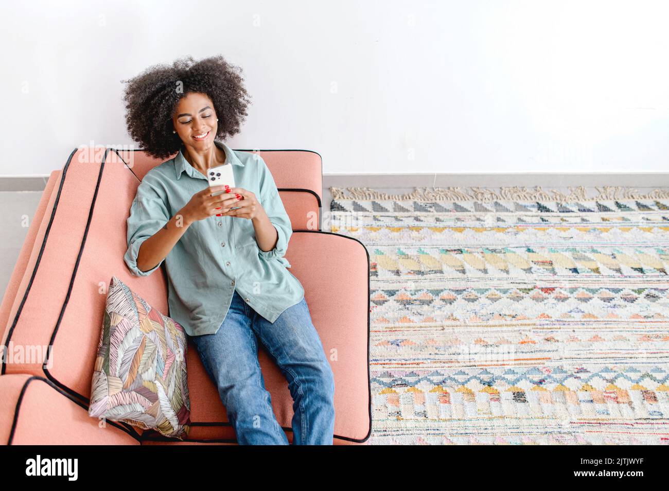 High angle view at calm young woman in casual wear with smartphone ...