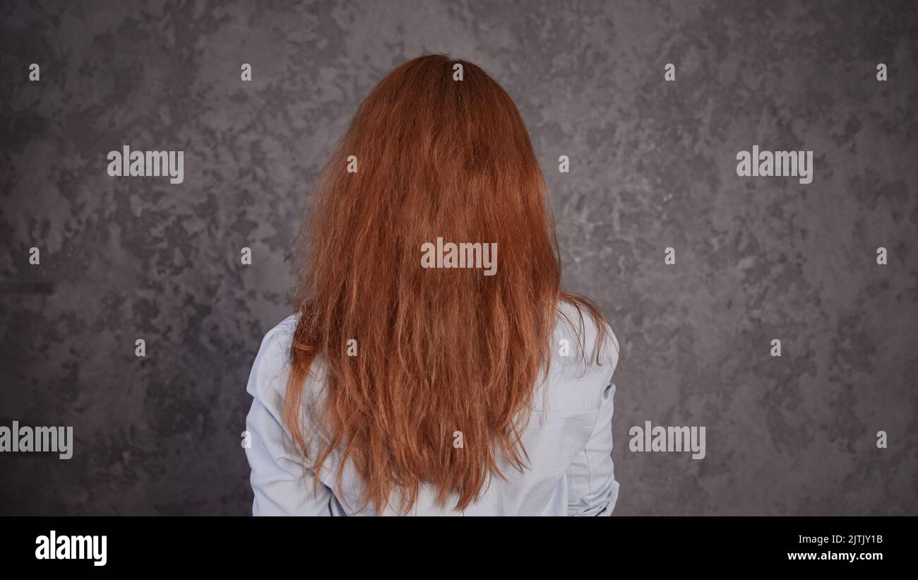 A young ginger hair girl standing facing the gray wall Stock Photo - Alamy