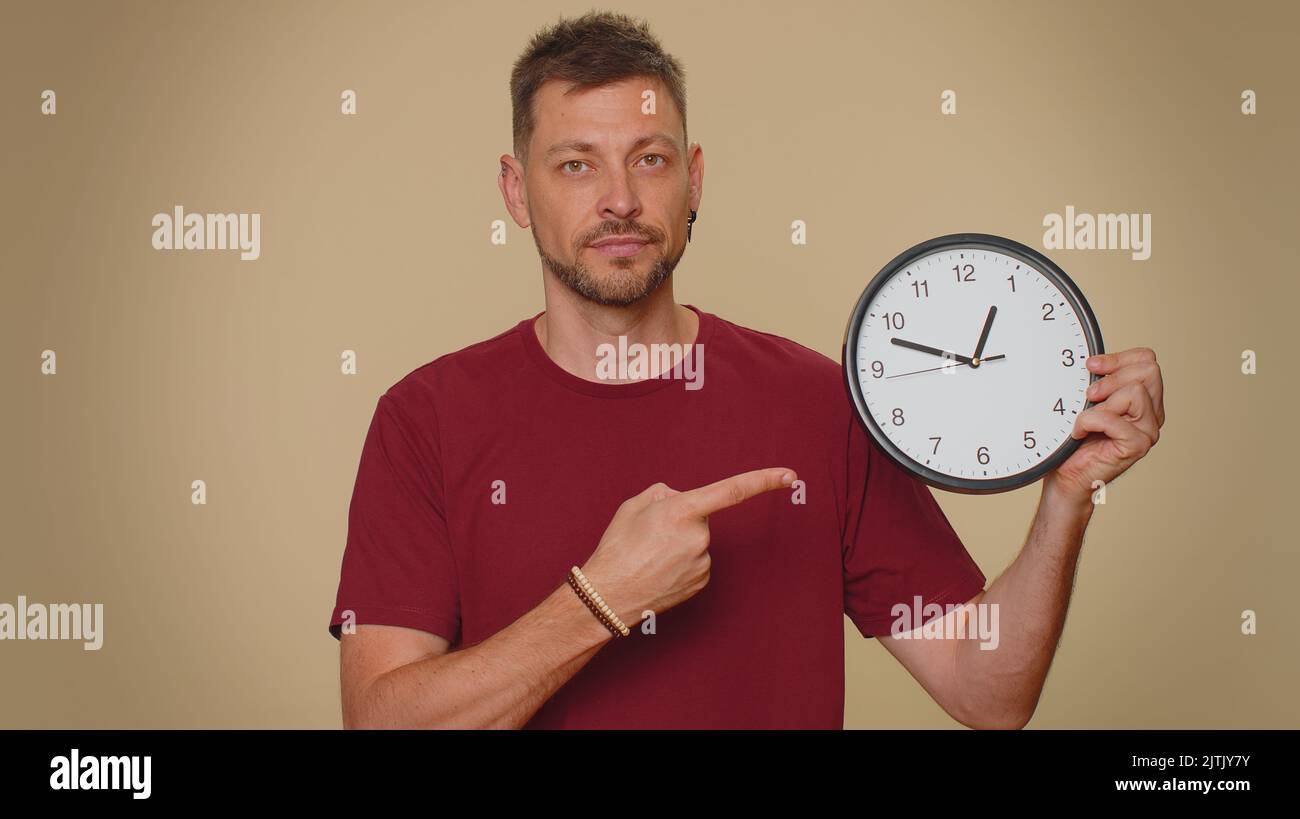 Handsome guy holding wall clock hi-res stock photography and images - Alamy