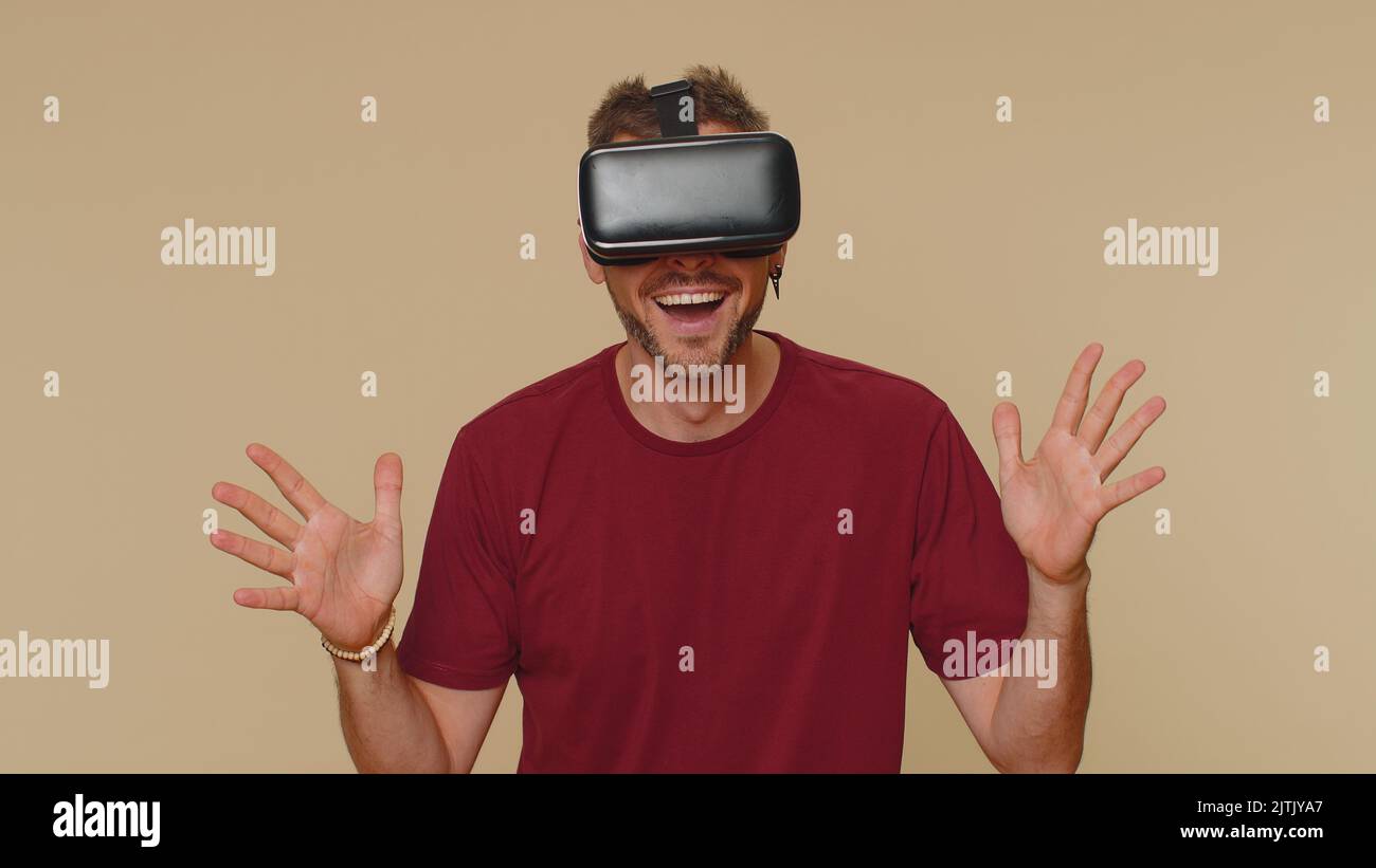 Bearded handsome young man using headset helmet app to play simulation ...