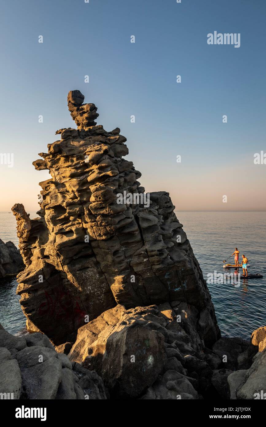 Two early morning paddleboarders pass the Faragghiuneddi, a surreal ...