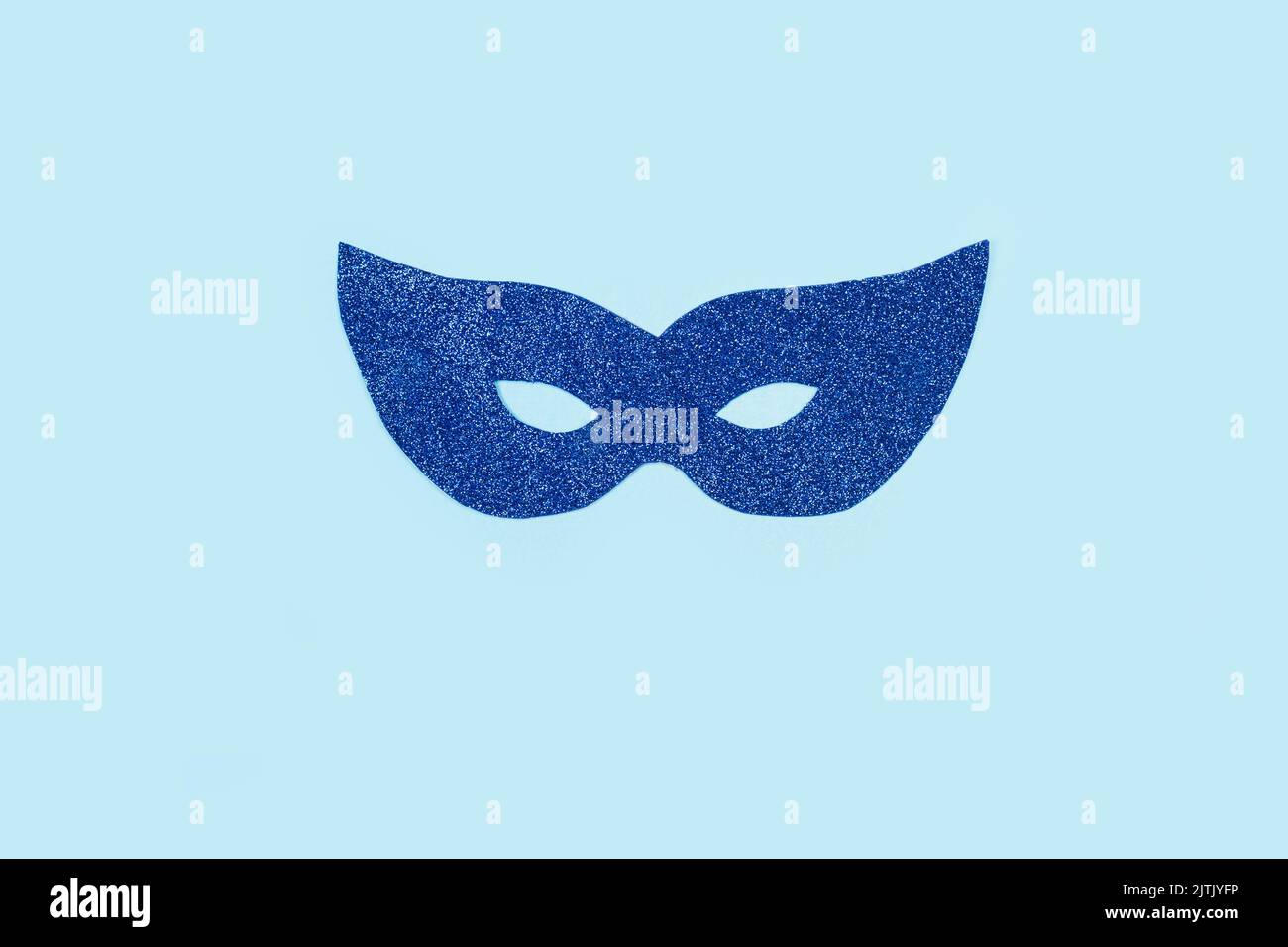 Blue party glitter eye mask on a light blue background with copy space ...