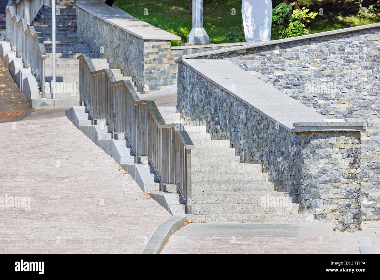 Granite steps in a modern city park with stainless steel metal railings ...