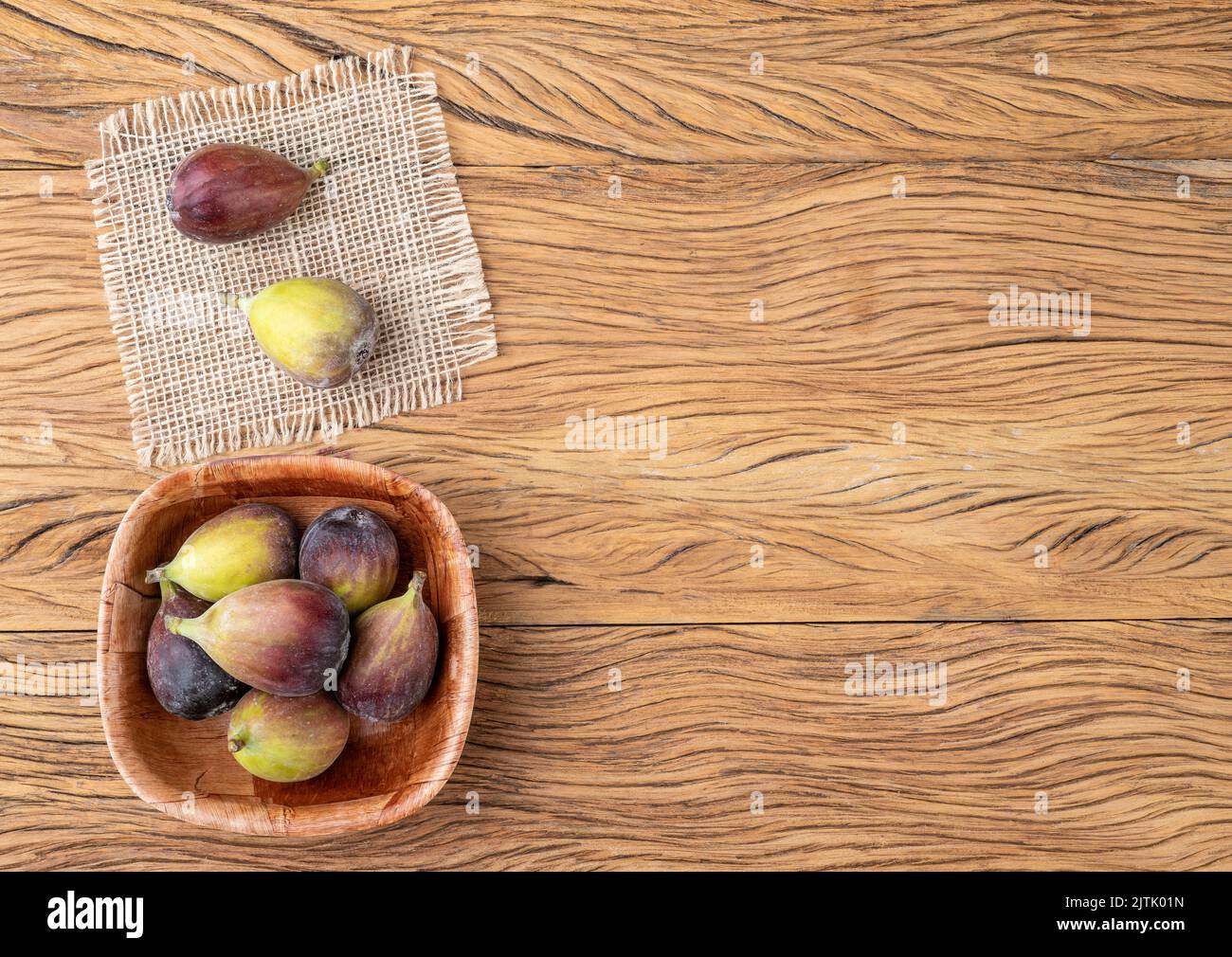 Figs in a bowl over wooden table with copy space Stock Photo - Alamy