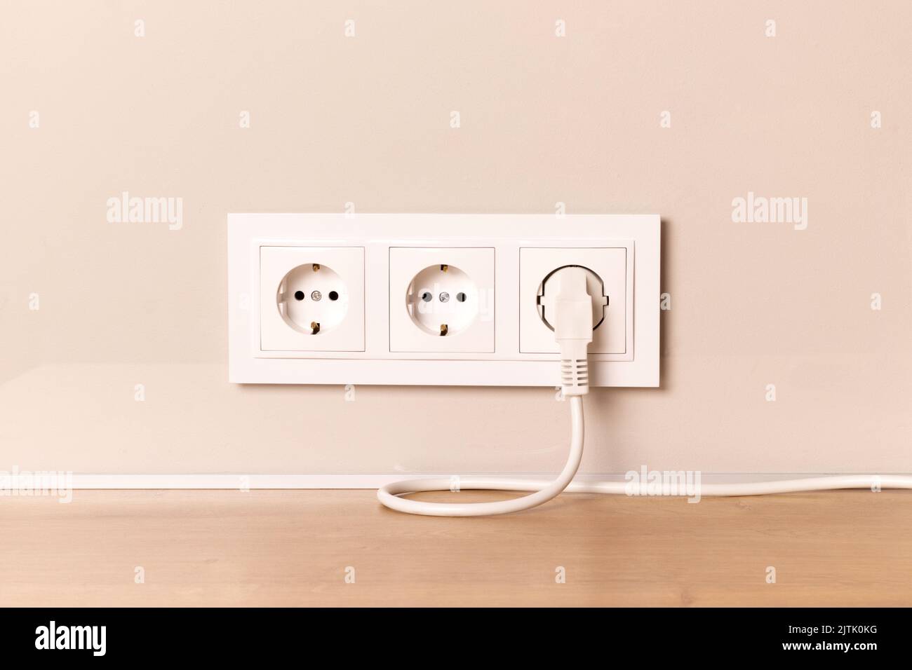 Group of white european electrical outlets with plug inserted into it ...