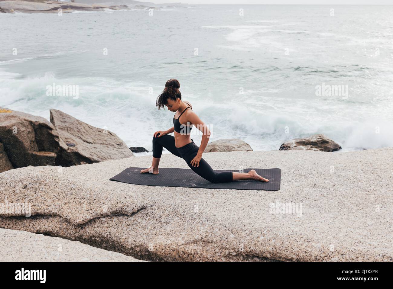 Female on mat warming up her body at bay. Woman athlete doing ...