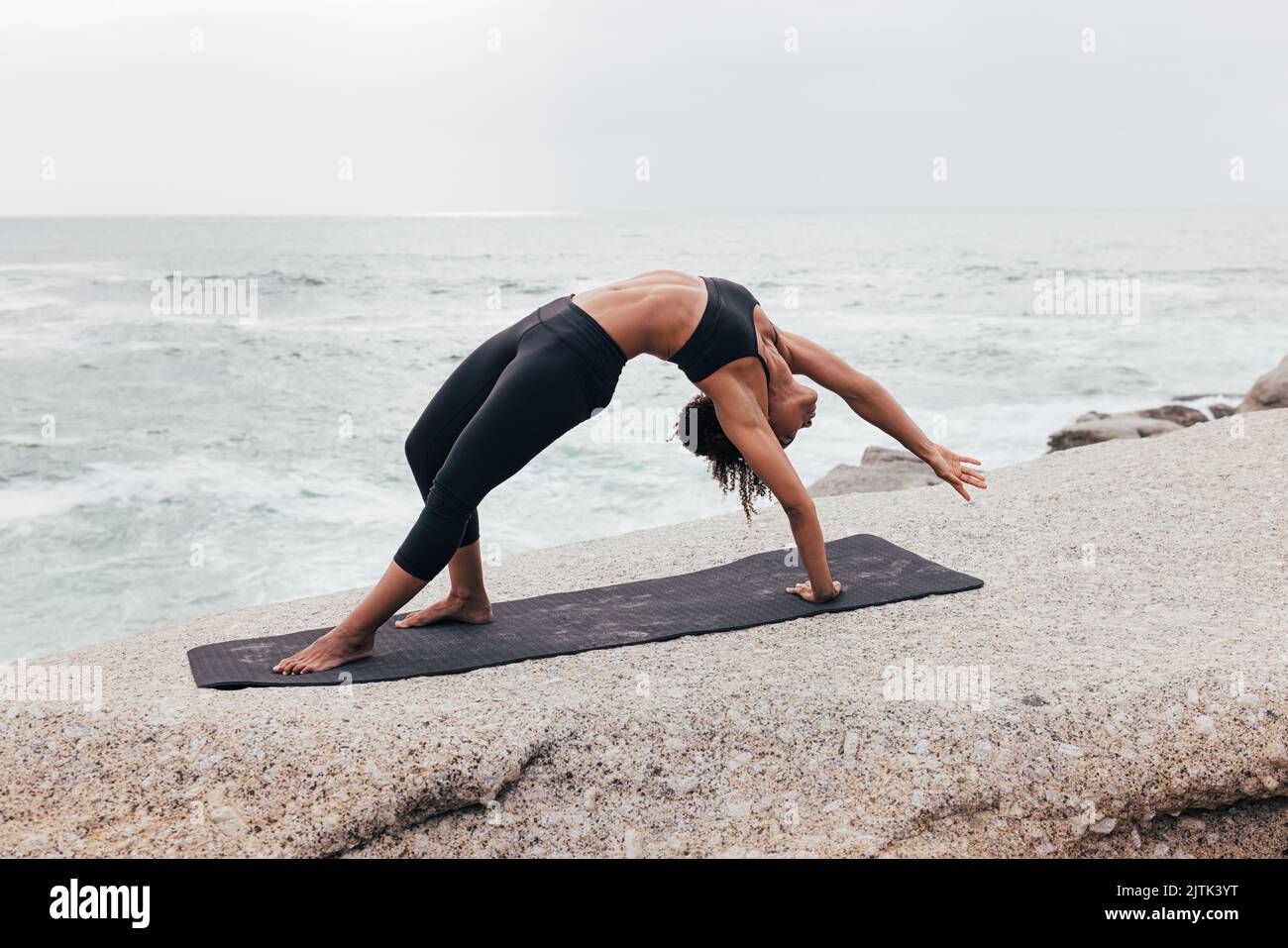 Woman doing Wild Thing yoga pose outdoors. Female practicing ...