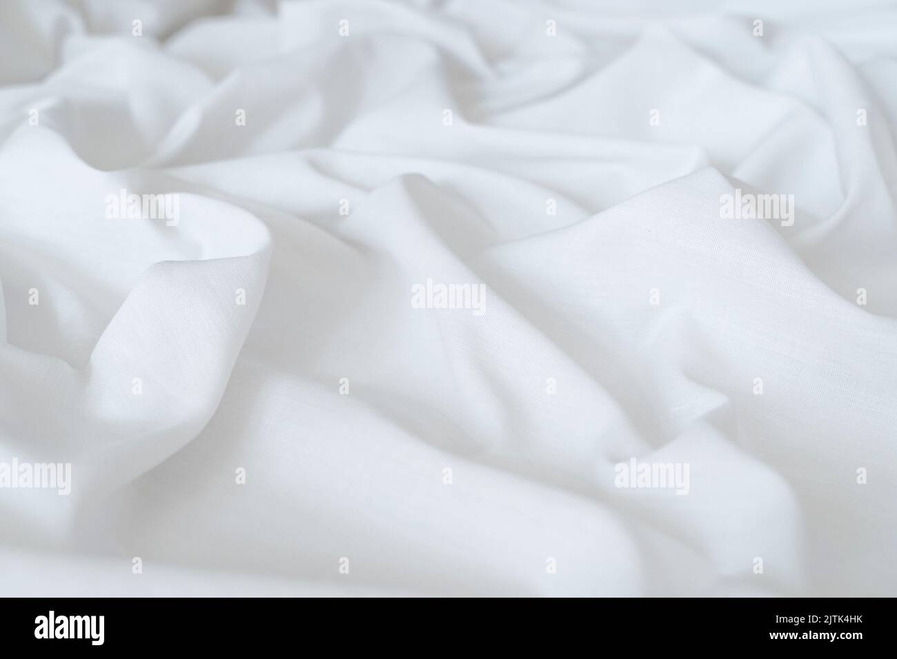 White drapery linen fabric background. Texture of the light surface of ...