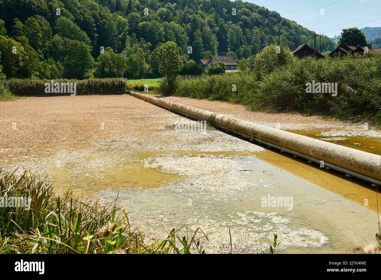 Dried Up Pond With Silty Water Residue And Water Pipe In Heat Summer ...
