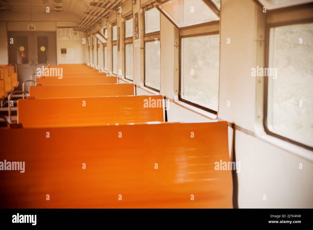 The interior of an old empty retro train car with orange seats on a ...