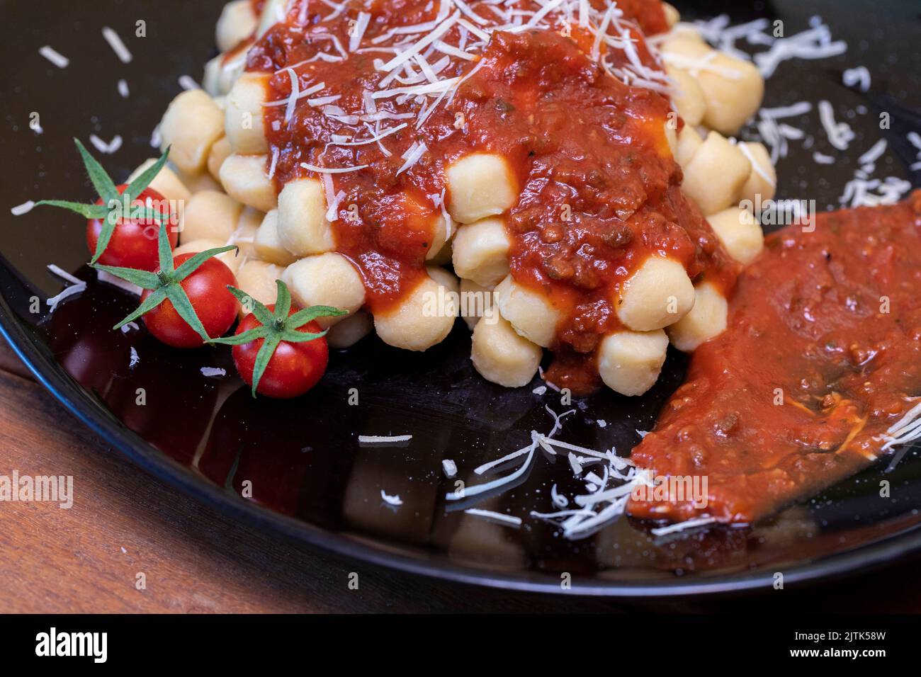 Close up on traditional italian potato gnocchi in tomato sauce with ...