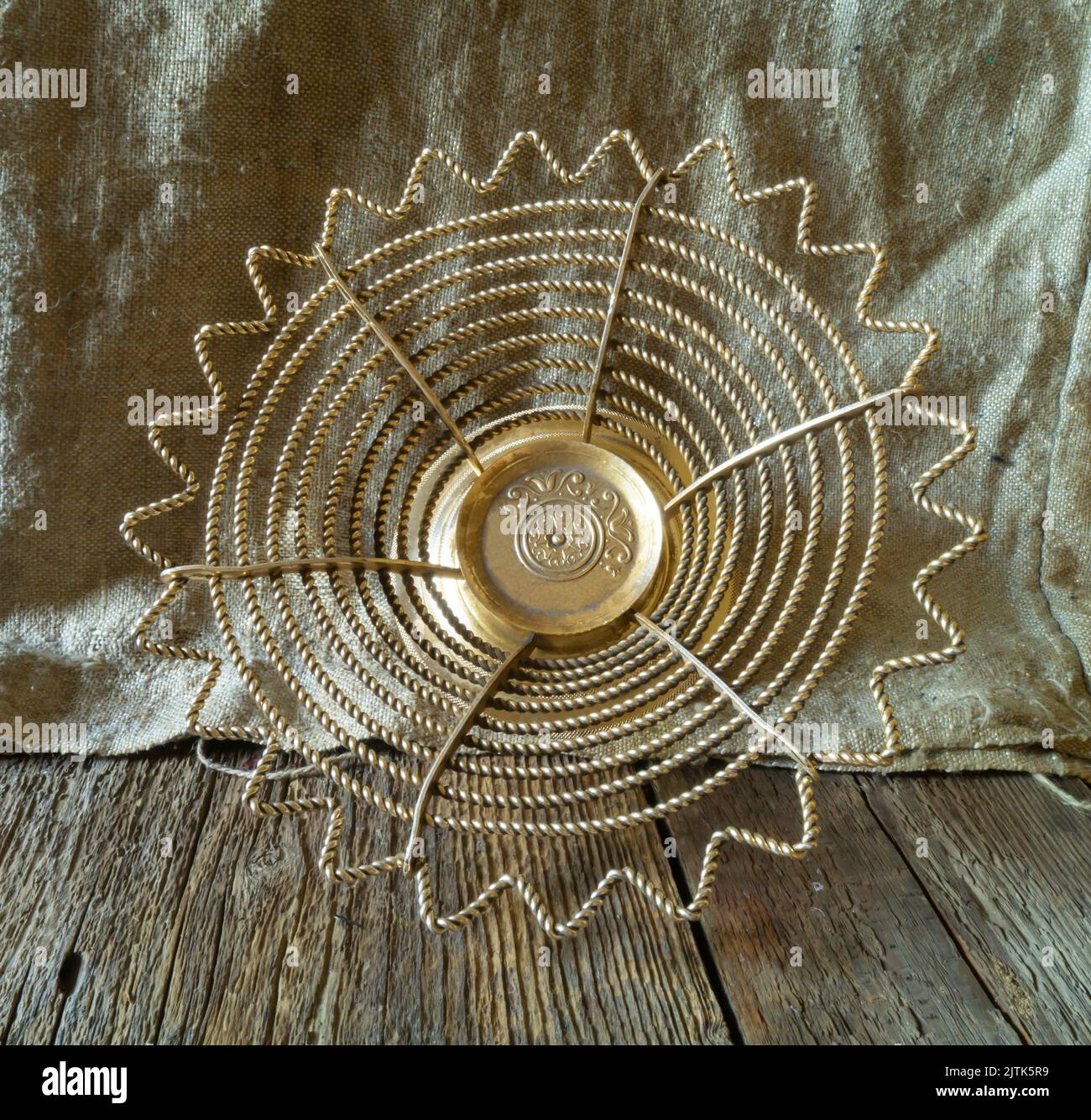 A plate made of braided wire on a background of burlap. Old kitchen ...