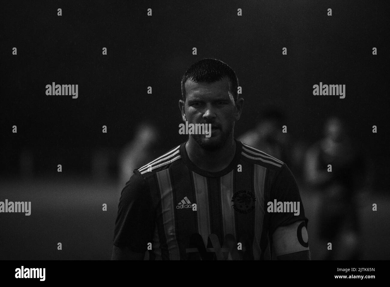 UK football player walking on pitch in the rain Stock Photo - Alamy