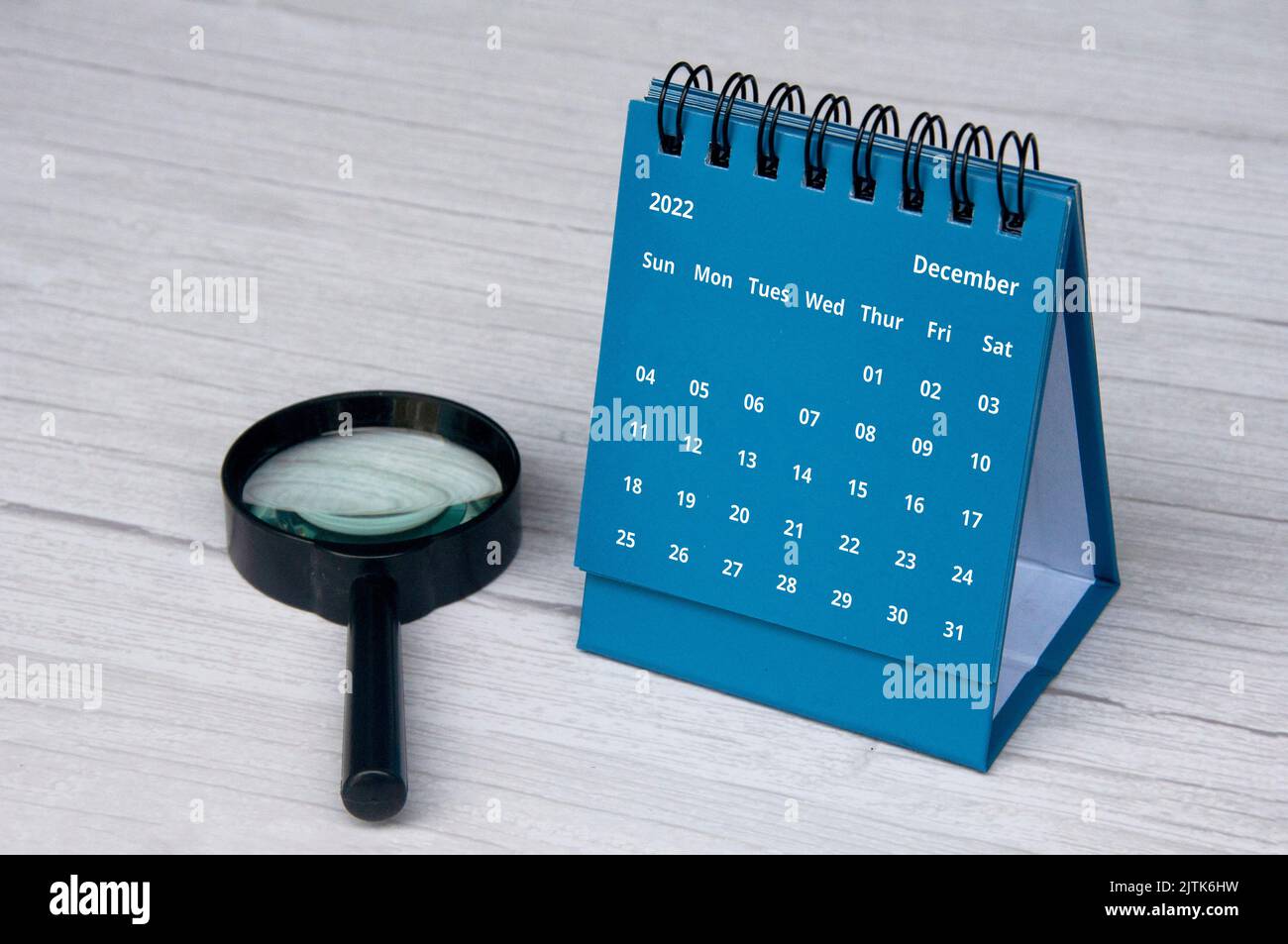 December 2022 blue color desk calendar on wooden desk with copy space ...