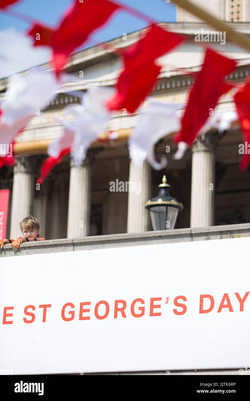 A spectator is seen behind decorations as people gather for St George’s ...