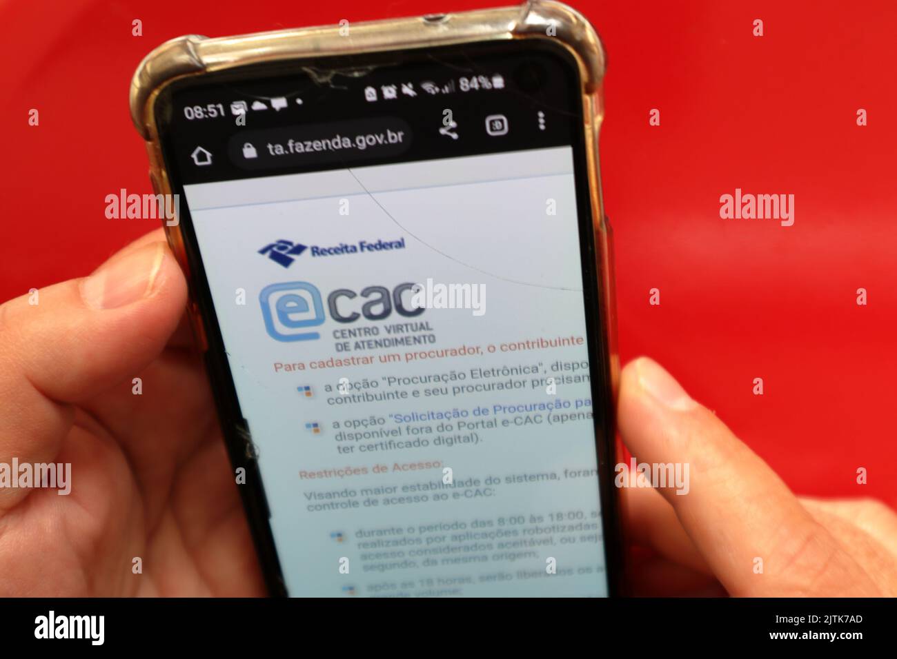 Top view of hand touching smartphone screen showing Brazilian IRS ...