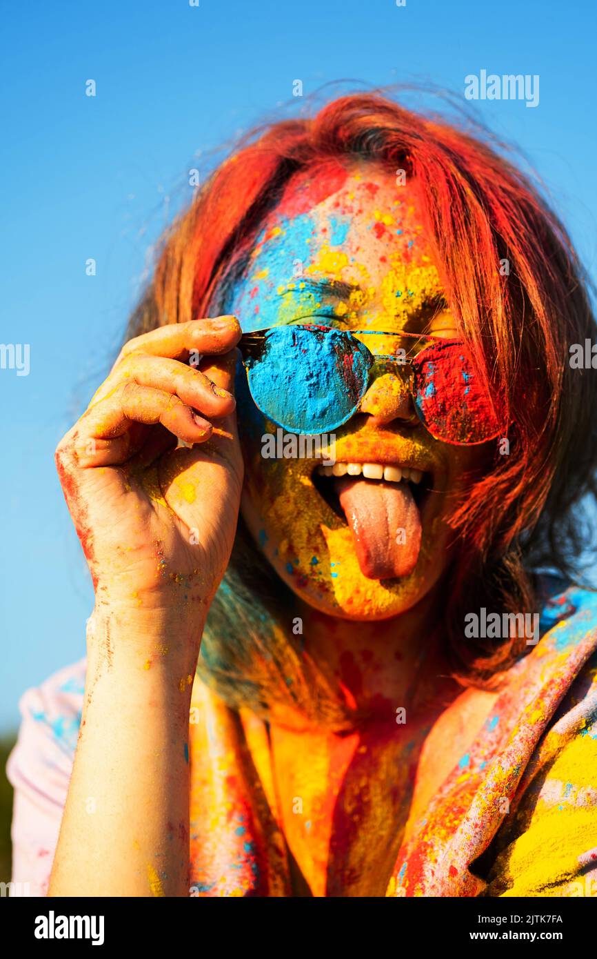 Woman covered in holi powder against blue sky. Holi colours festival ...
