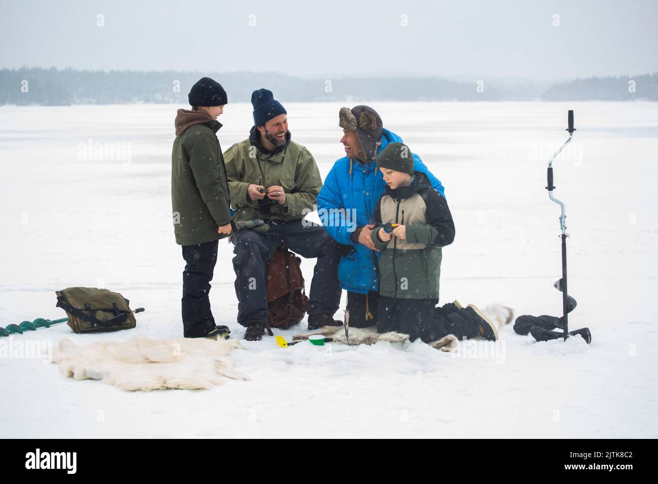 Cheerful male friends enjoying with sons at frozen lake Stock Photo - Alamy