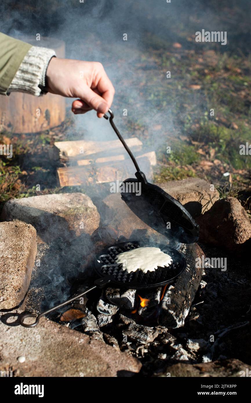 Mature man preparing waffles at bonfire Stock Photo - Alamy