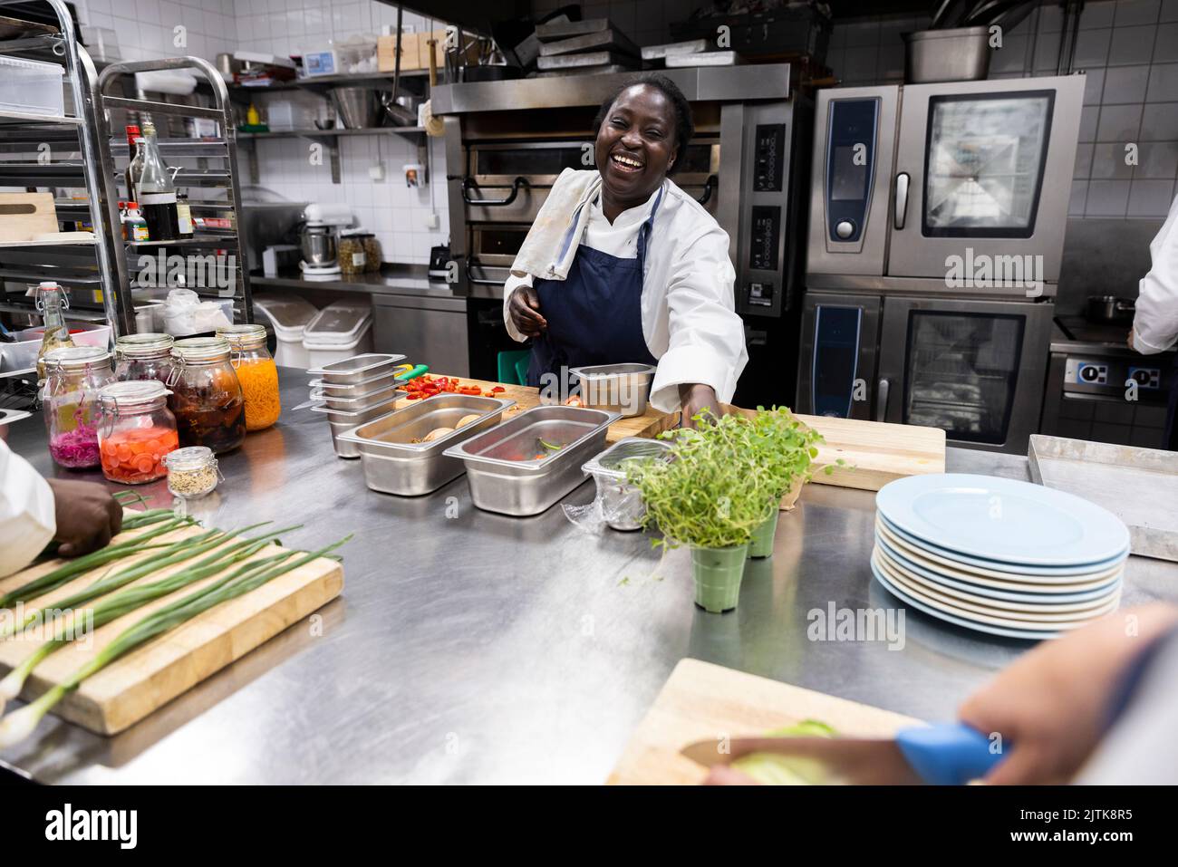 Chef smiling while working in kitchen of restaurant Stock Photo - Alamy