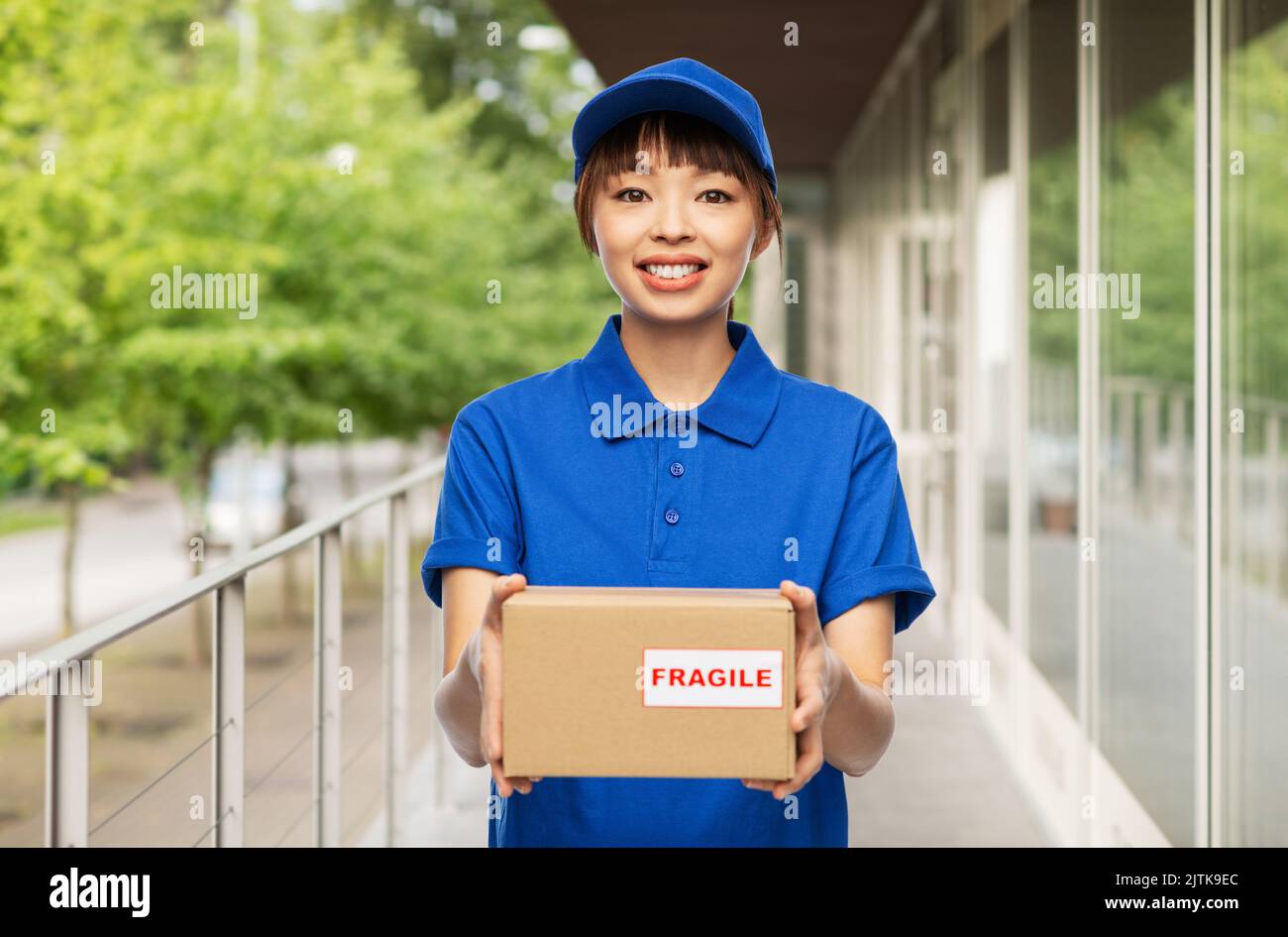 happy smiling delivery woman holding parcel box Stock Photo - Alamy